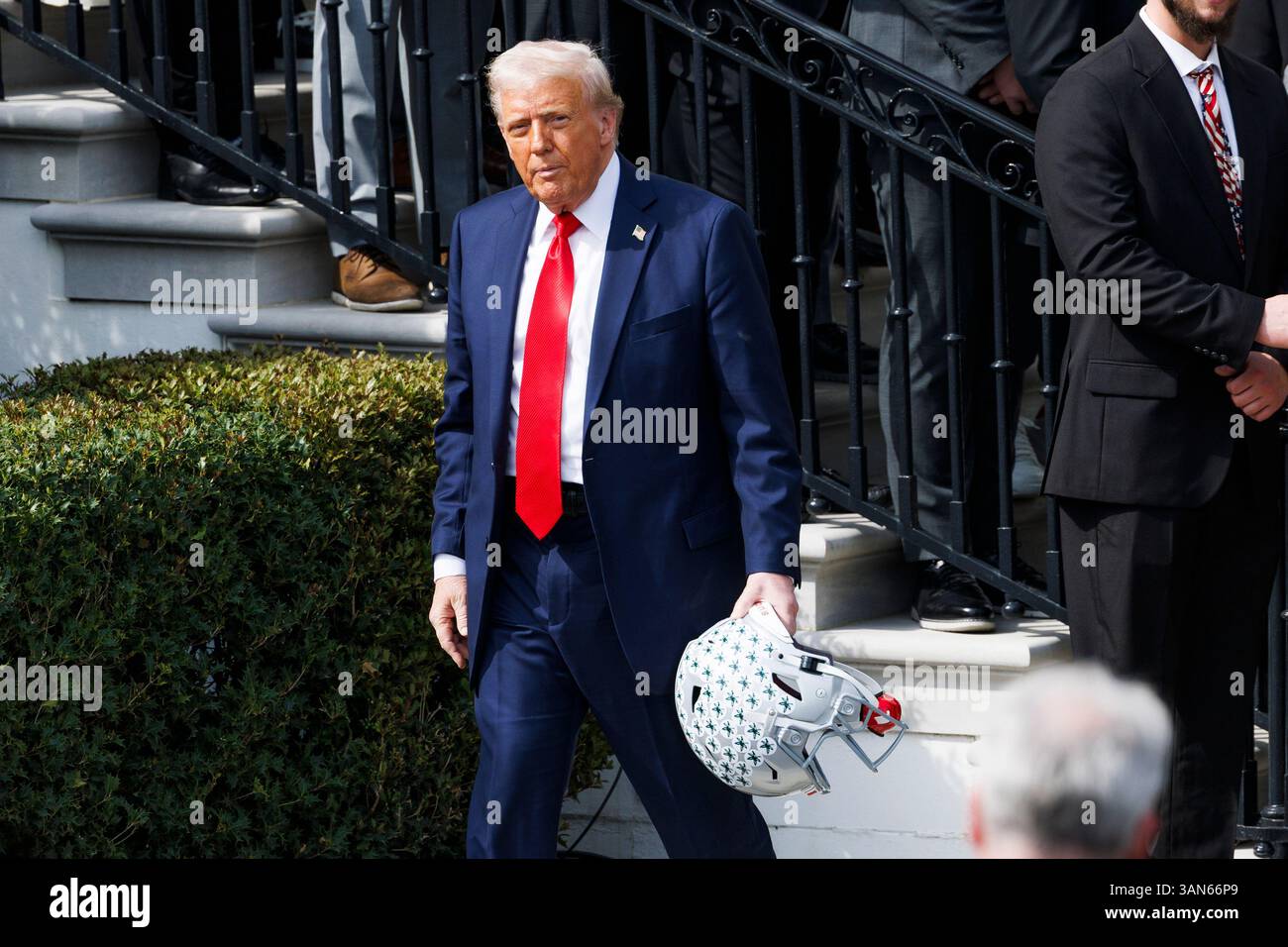President Donald Trump holds a commemorative football helmet as he ...