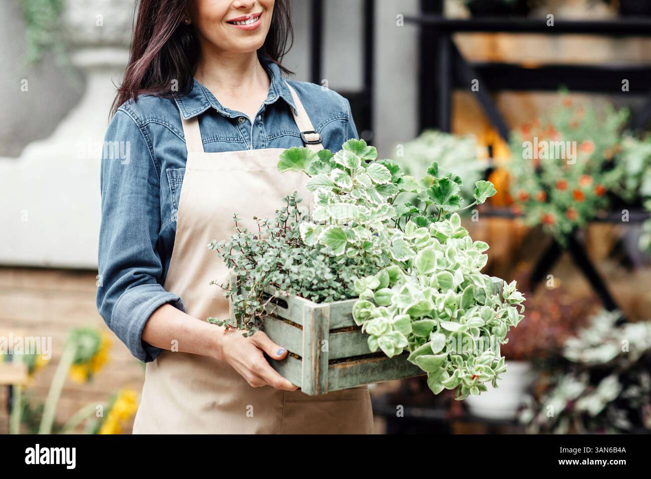 Beautiful woman florist shows fresh plants in flower studio Stock Photo ...