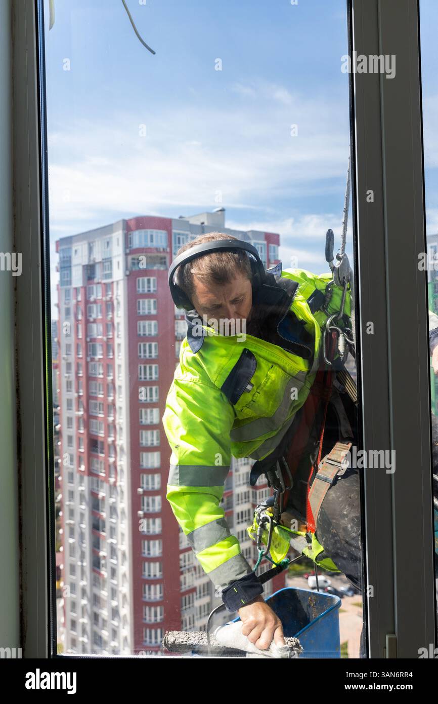 Skilled Window Cleaner Bravely Working on High Rise Building, Ensuring ...