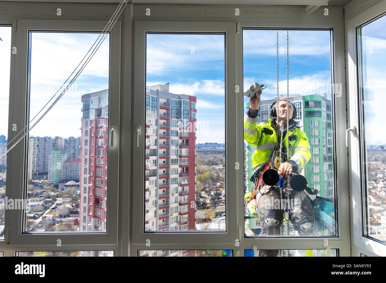 Professional Window Cleaner at Work in High-Rise Building, Showcasing ...