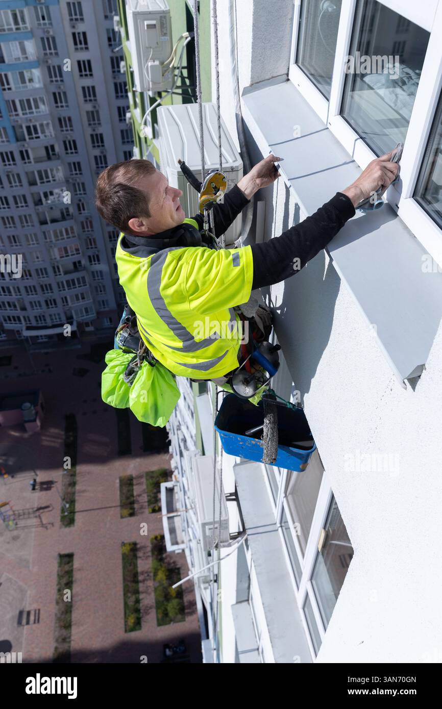 Professional Window Cleaner Performing High-Rise Maintenance on ...