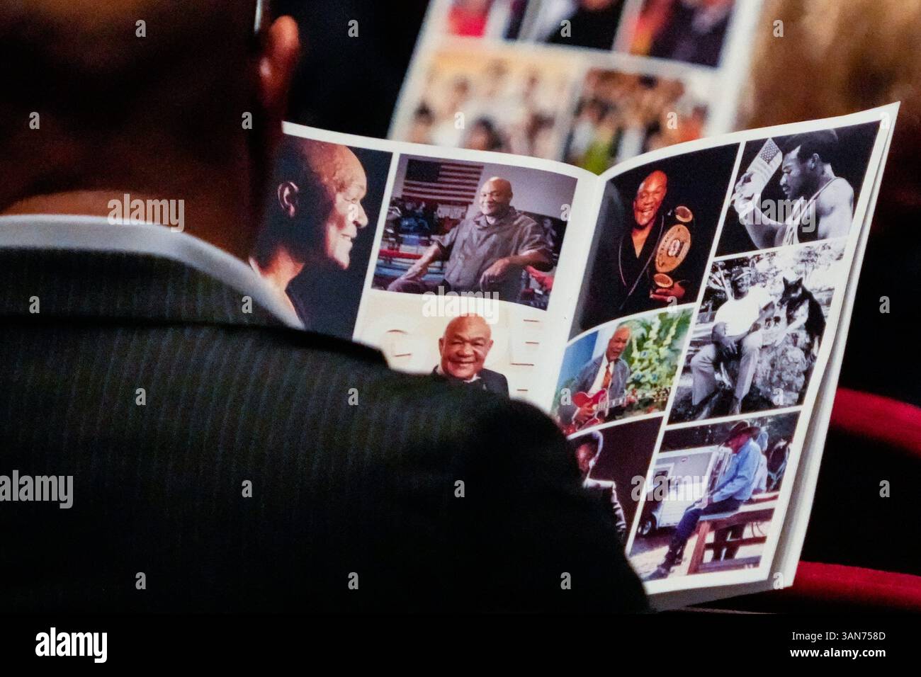 A mourner looks through photos in a program during a memorial service ...