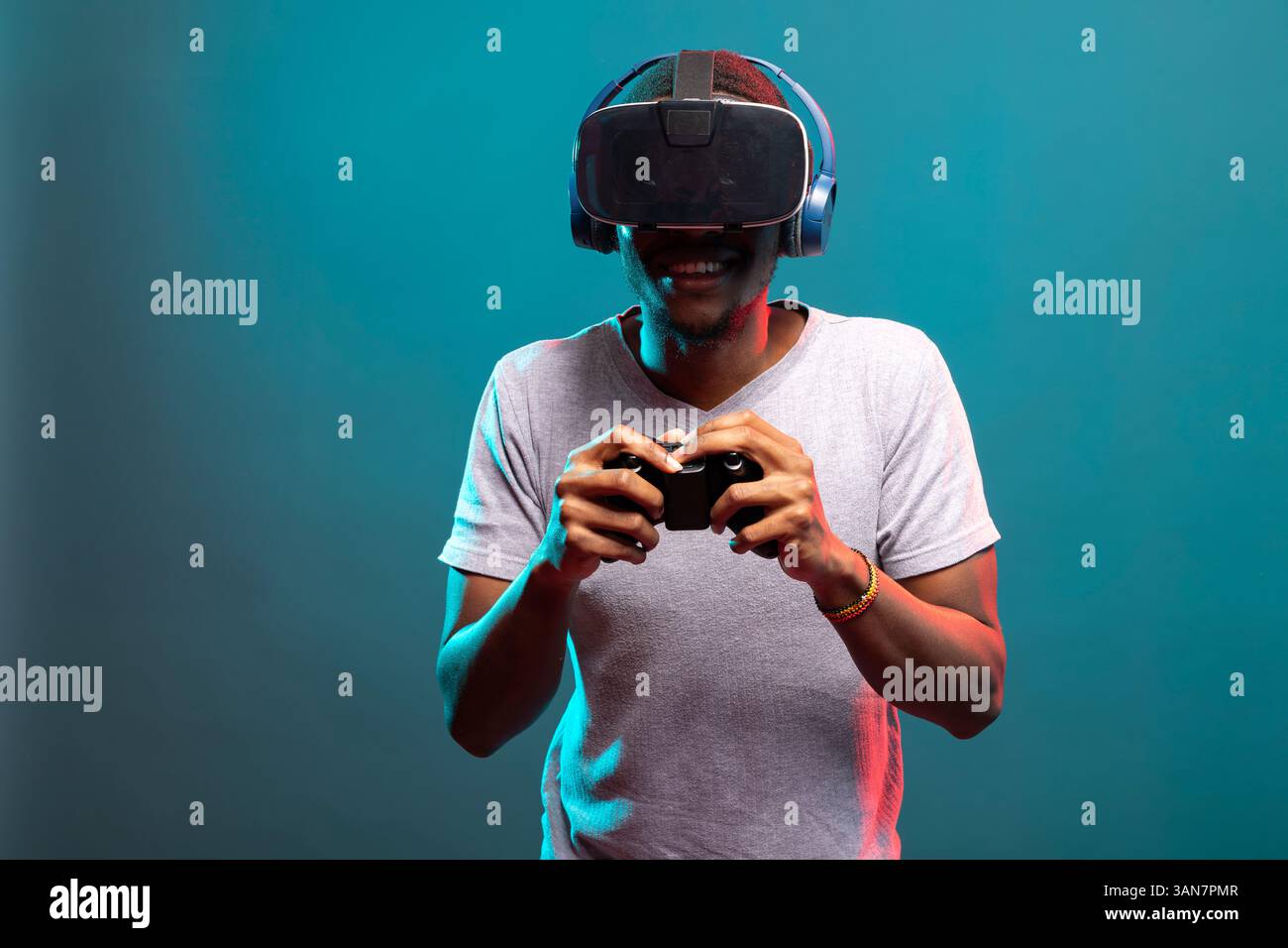 African American man wearing VR headset, holding a game controller and ...