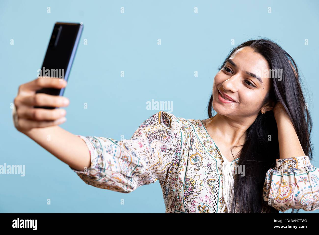 Pleased cheerful person using her smartphone to take selfies on social ...