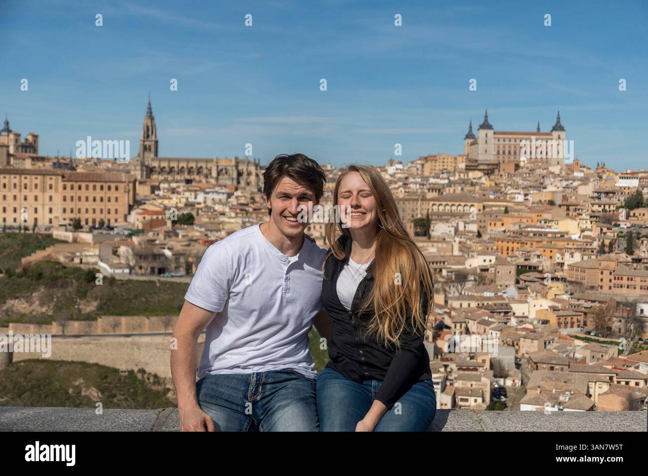 A couple happily poses for a picture near a beautiful skyline Stock ...