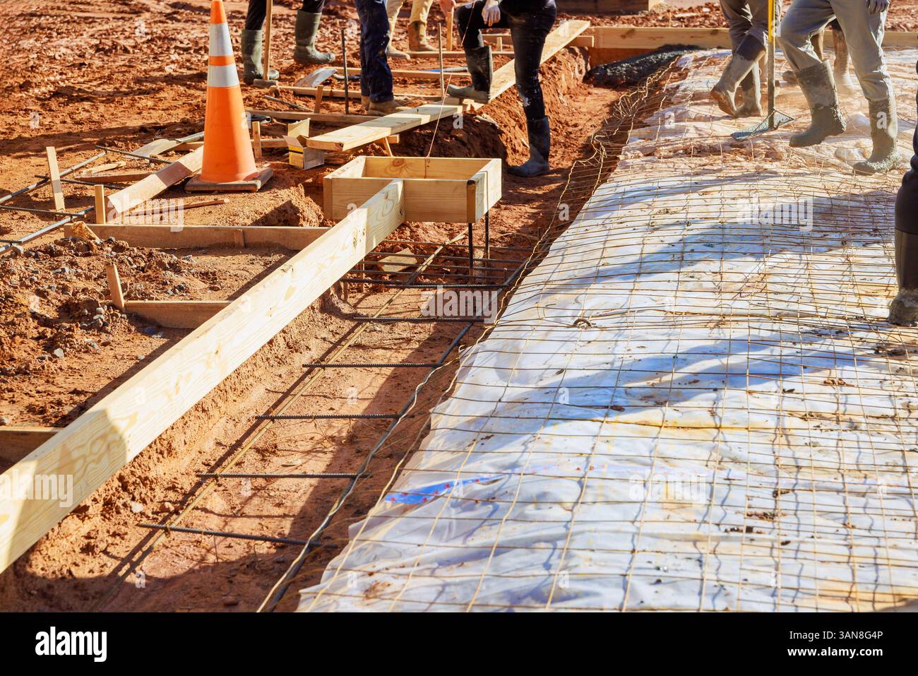 Construction crew prepares concrete foundation slab with rebar mesh for ...