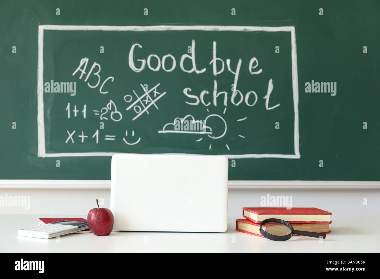Blackboard with text GOODBYE SCHOOL, drawings and teacher's table in ...