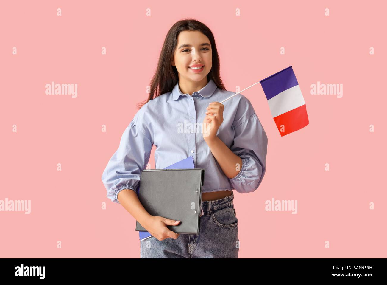 Female French language teacher with clipboard and flag on pink ...