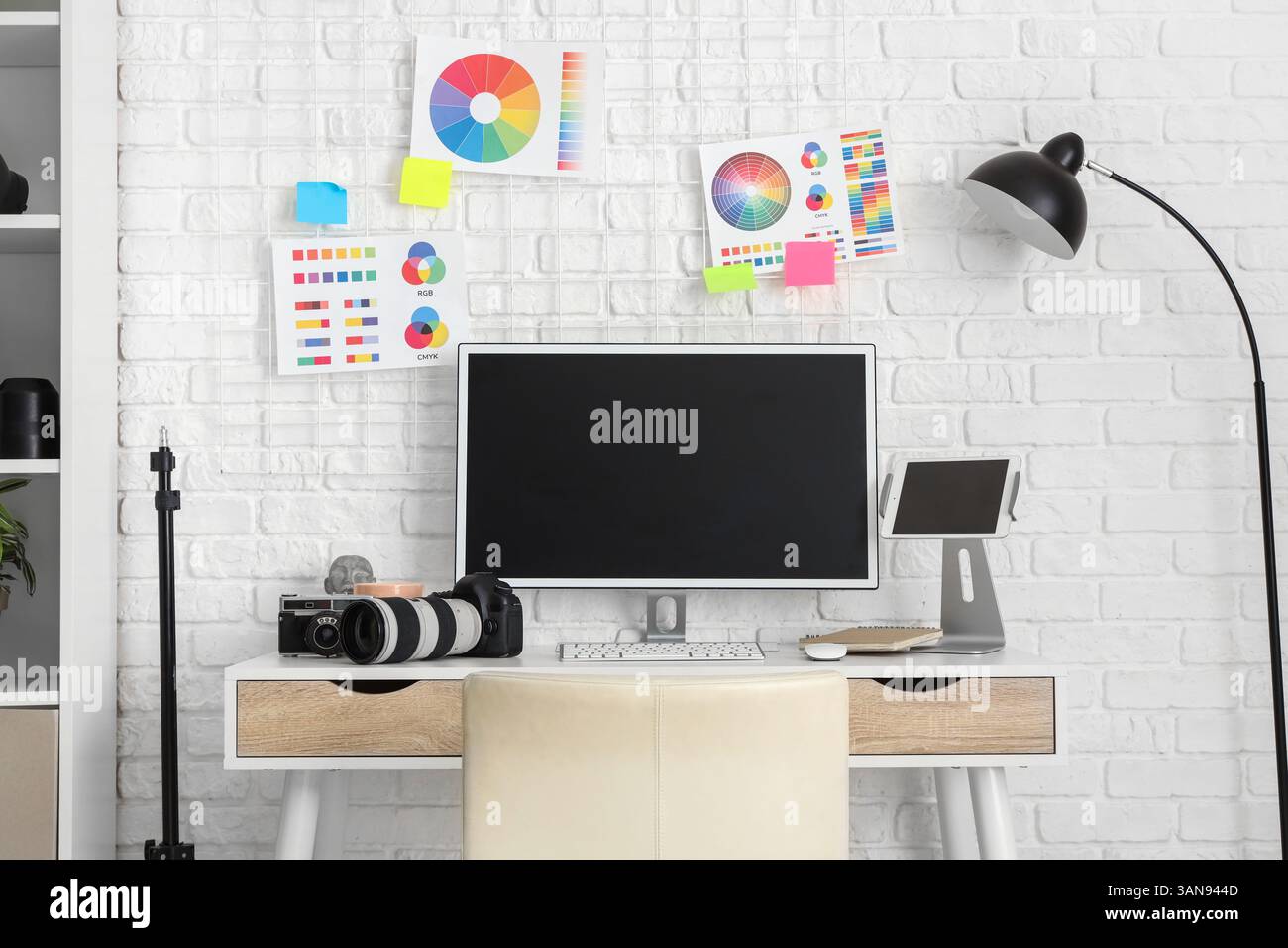 Photographer workplace with computer, color wheel charts and photo ...