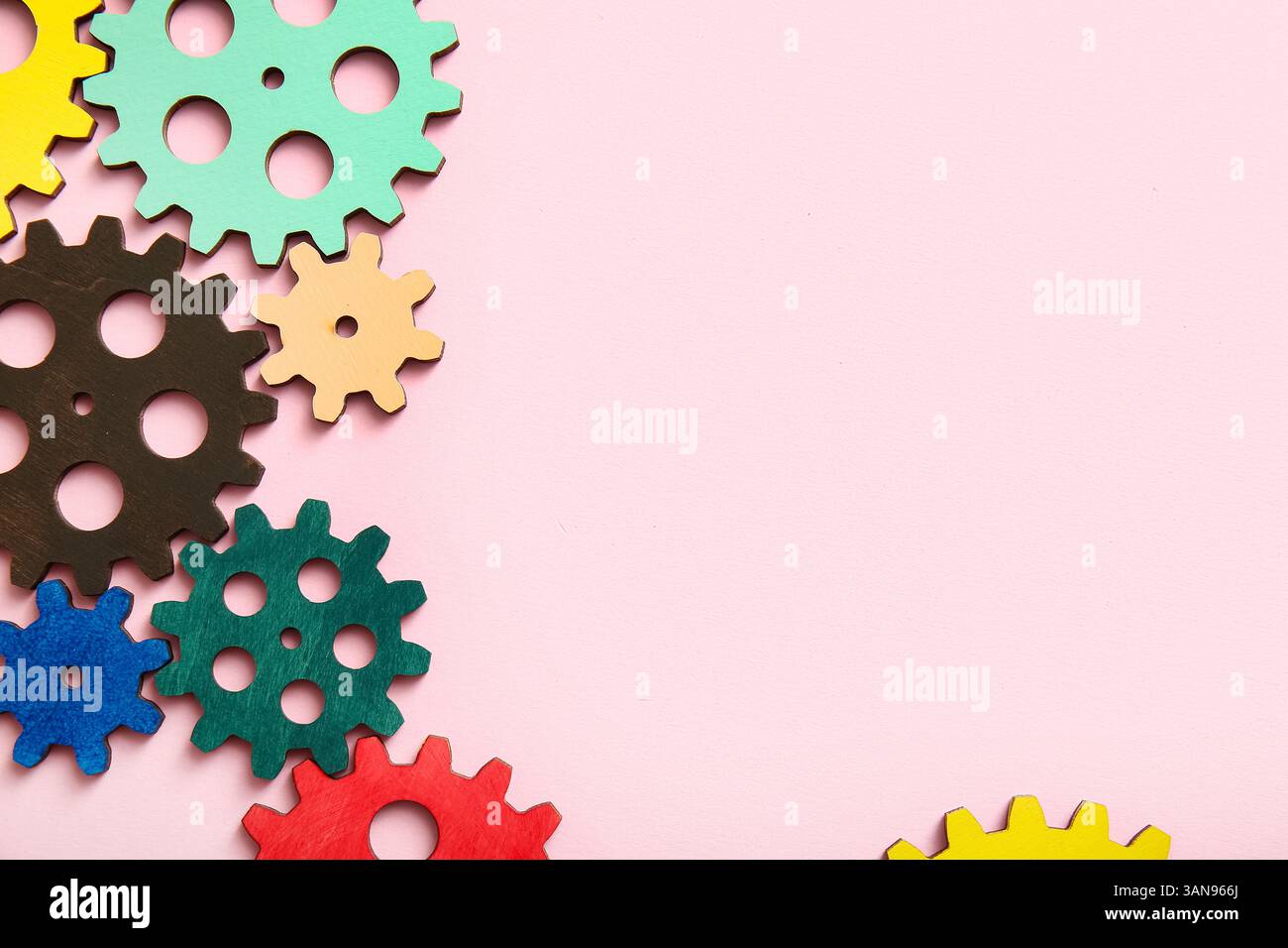 Wooden gears on pink background Stock Photo - Alamy