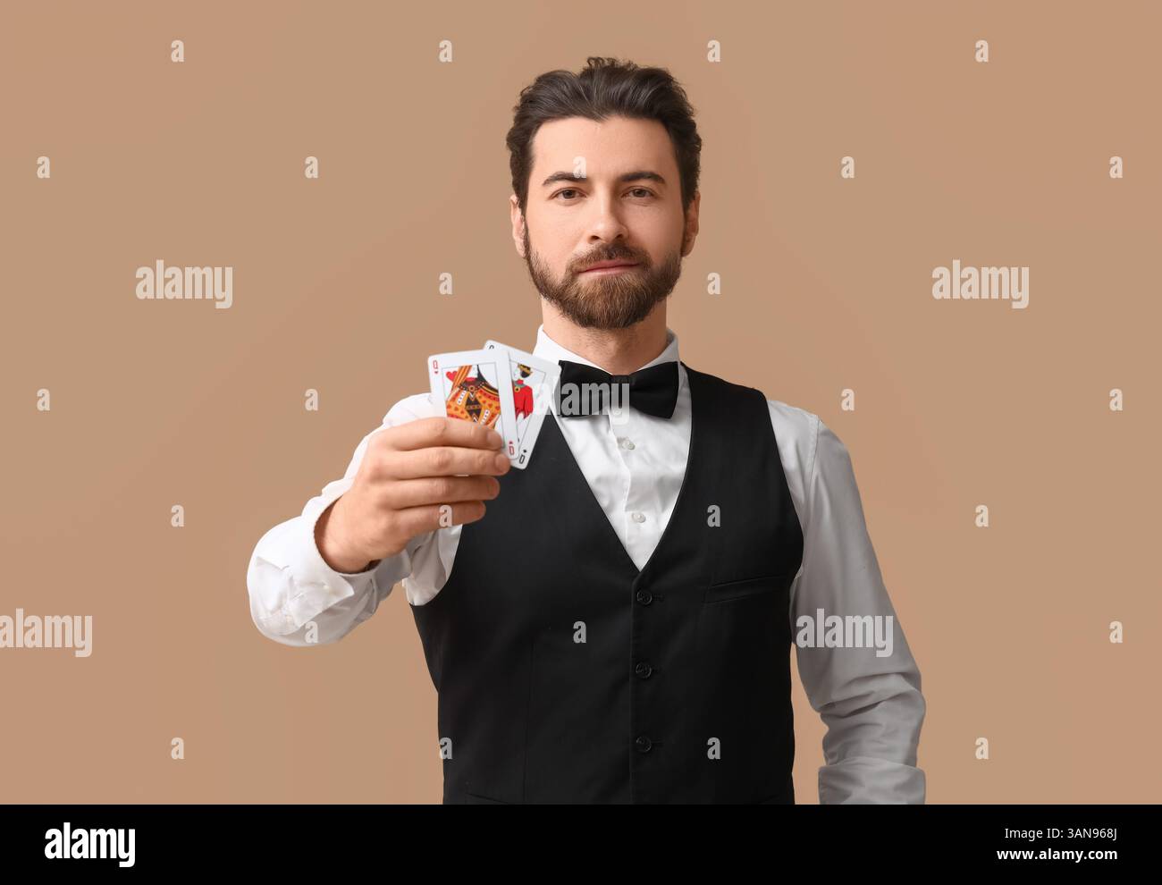 Handsome male banker with playing cards for poker on beige background ...