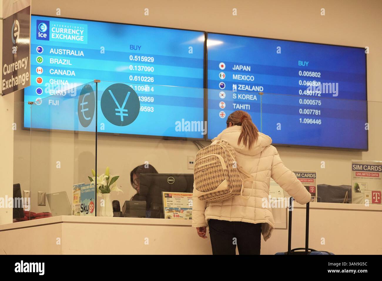 A traveler stands at the window of an ICE International Currency ...