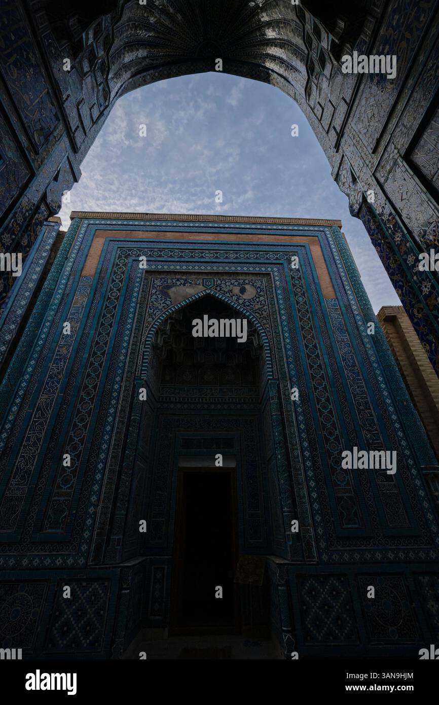 The blue tiled front facade of a mausoleum, framed in an arch from ...