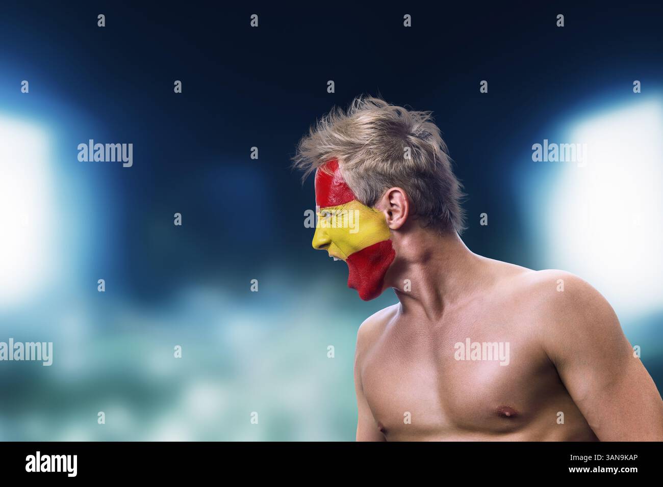 Football fan with spain flag painted on his face in front of night ...