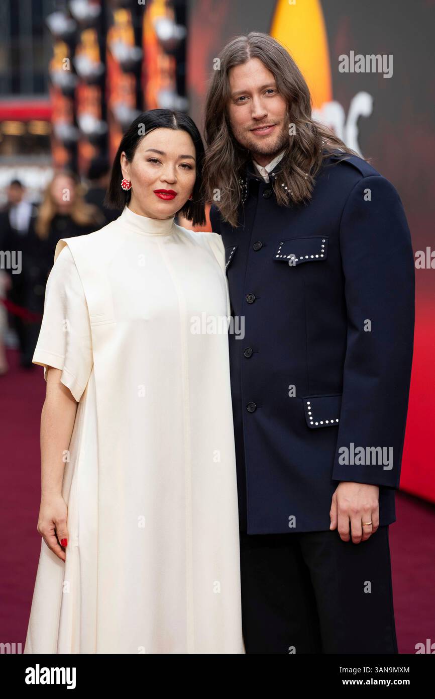 Serena McKinney, left, and Ludwig Goransson pose for photographers upon ...