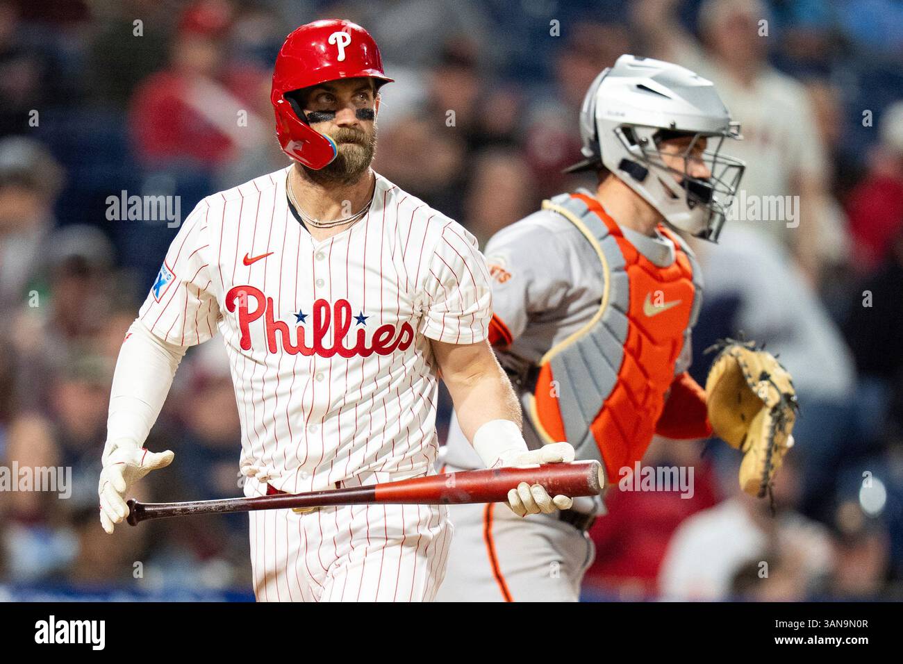 Philadelphia Phillies' Bryce Harper, left, looks on after striking out ...