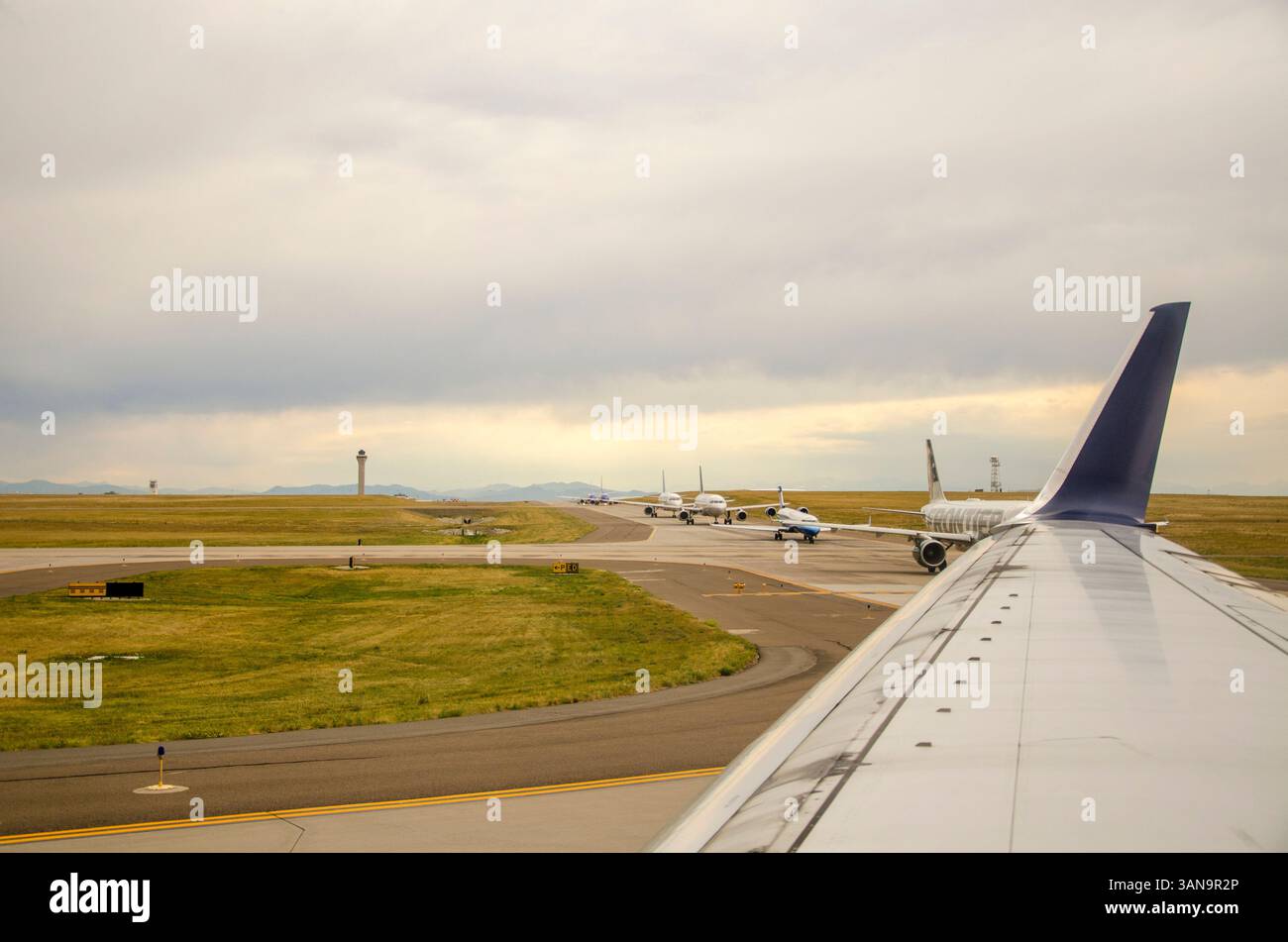 Airplane on Runway Amidst Waiting Aircraft and Tower in View Stock ...