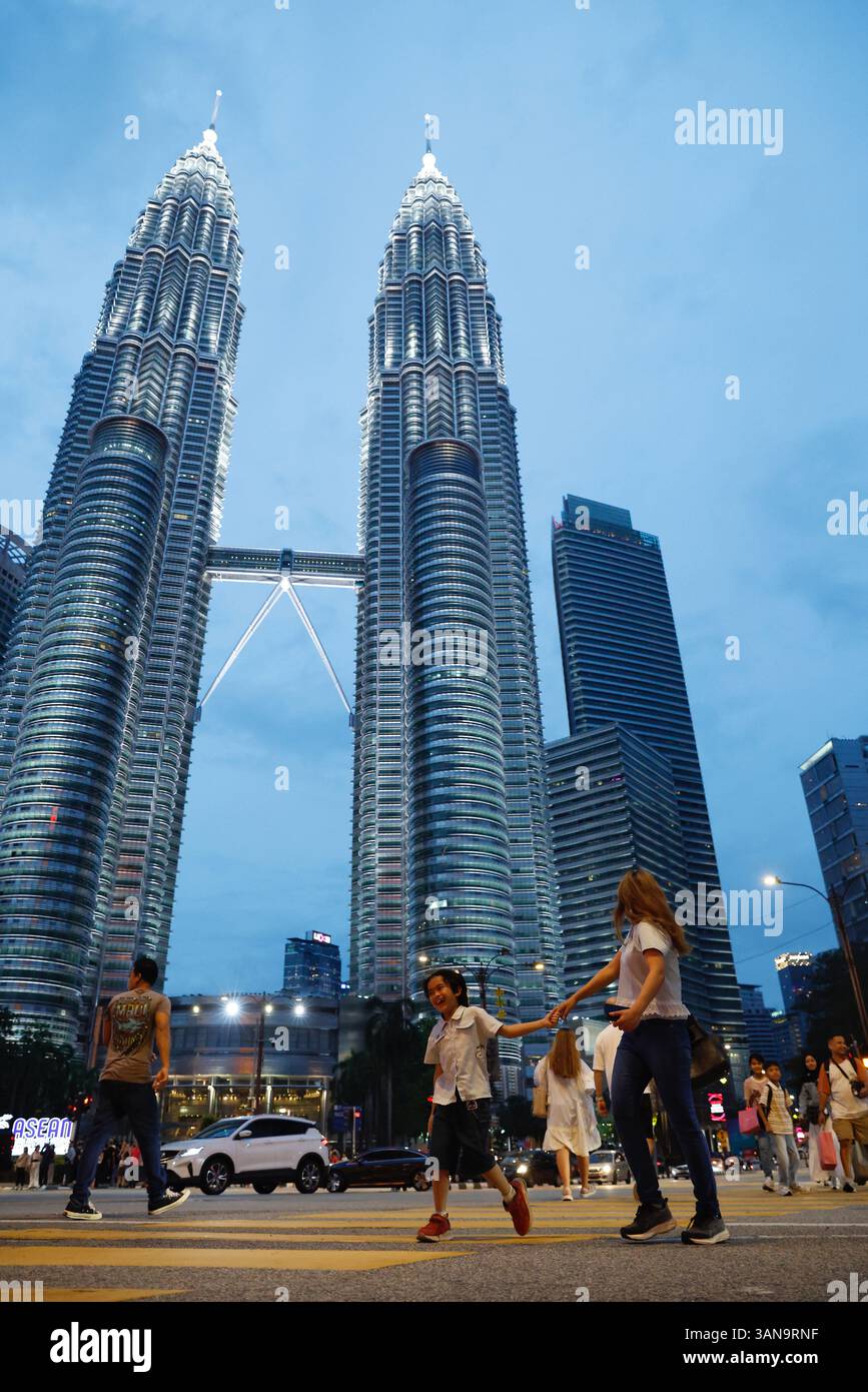 Kuala Lumpur, Malaysia.13th April 2025. People walk by Petronas Twin ...