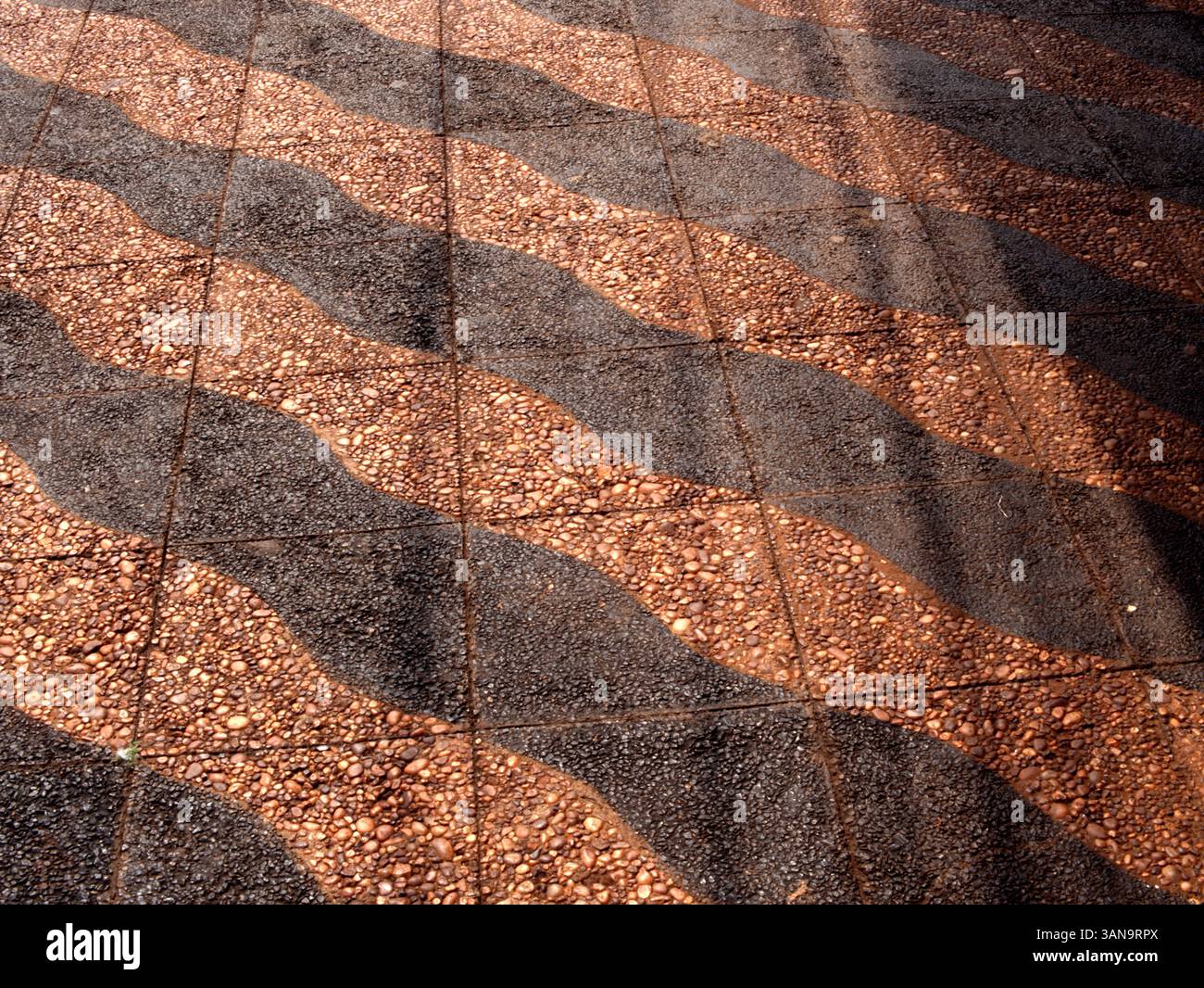 Close-up of a decorative pavement featuring a wavy pattern made of ...