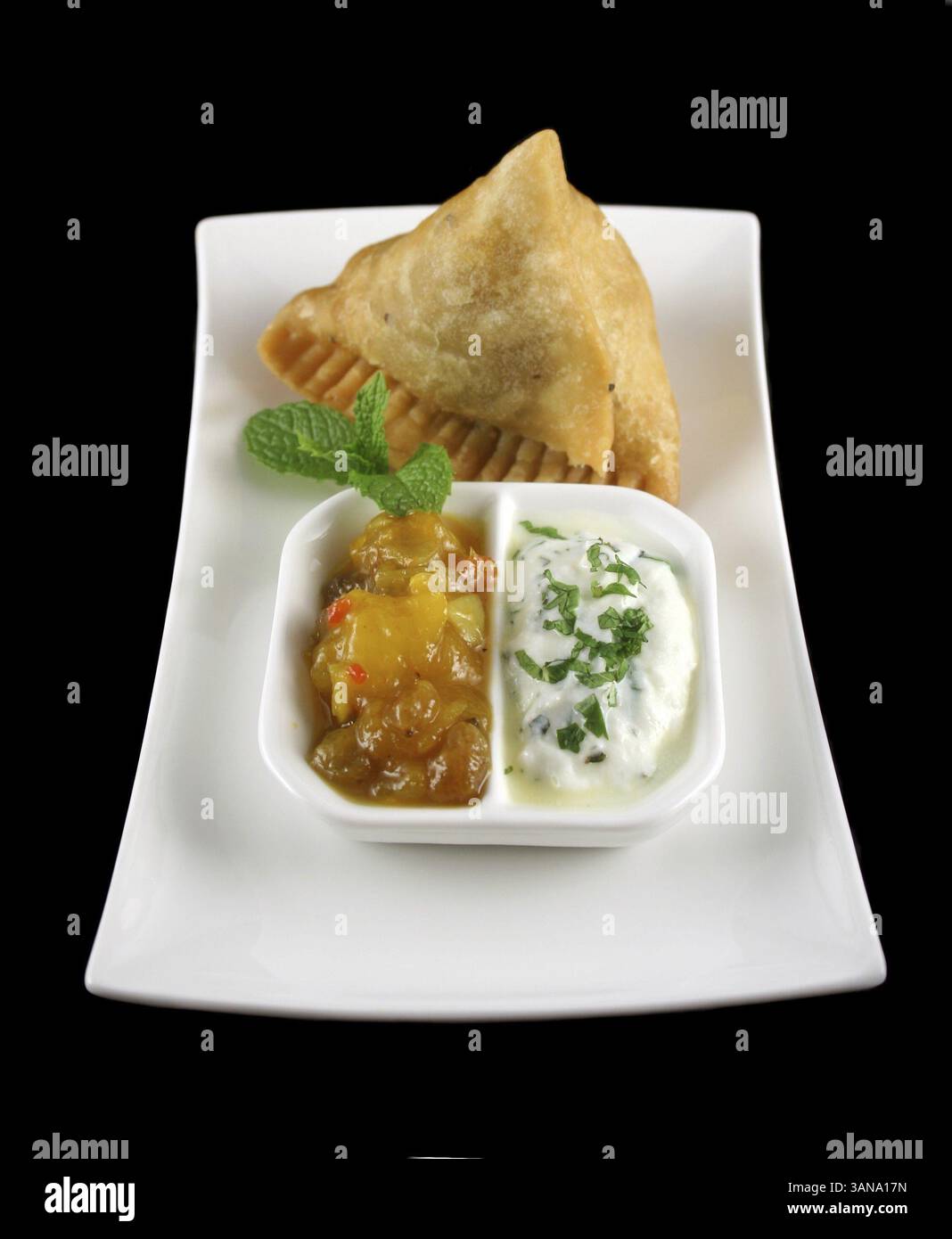 Indian samosa with mango chutney and herb yogurt Stock Photo - Alamy