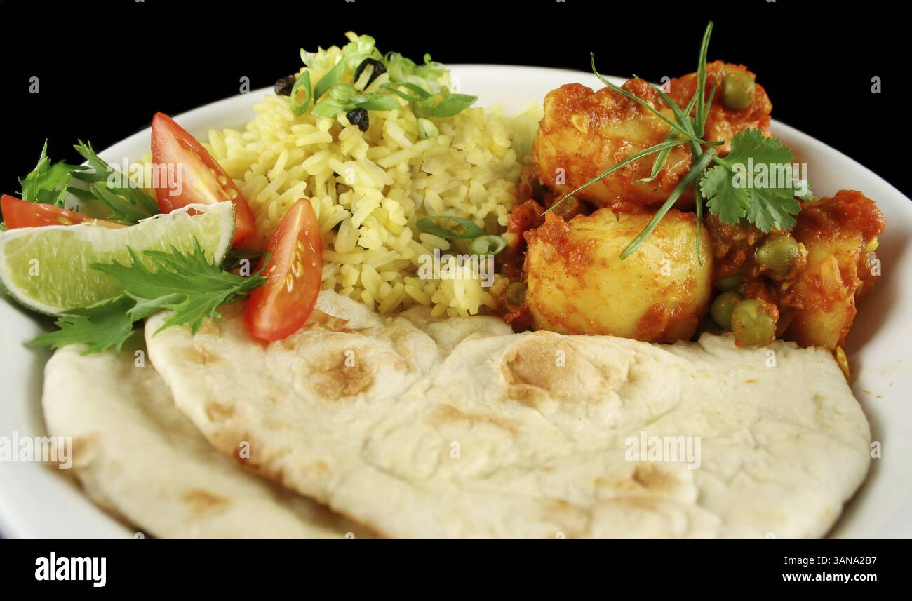 Indian pea and potato curry with tumeric rice and a side salad Stock ...