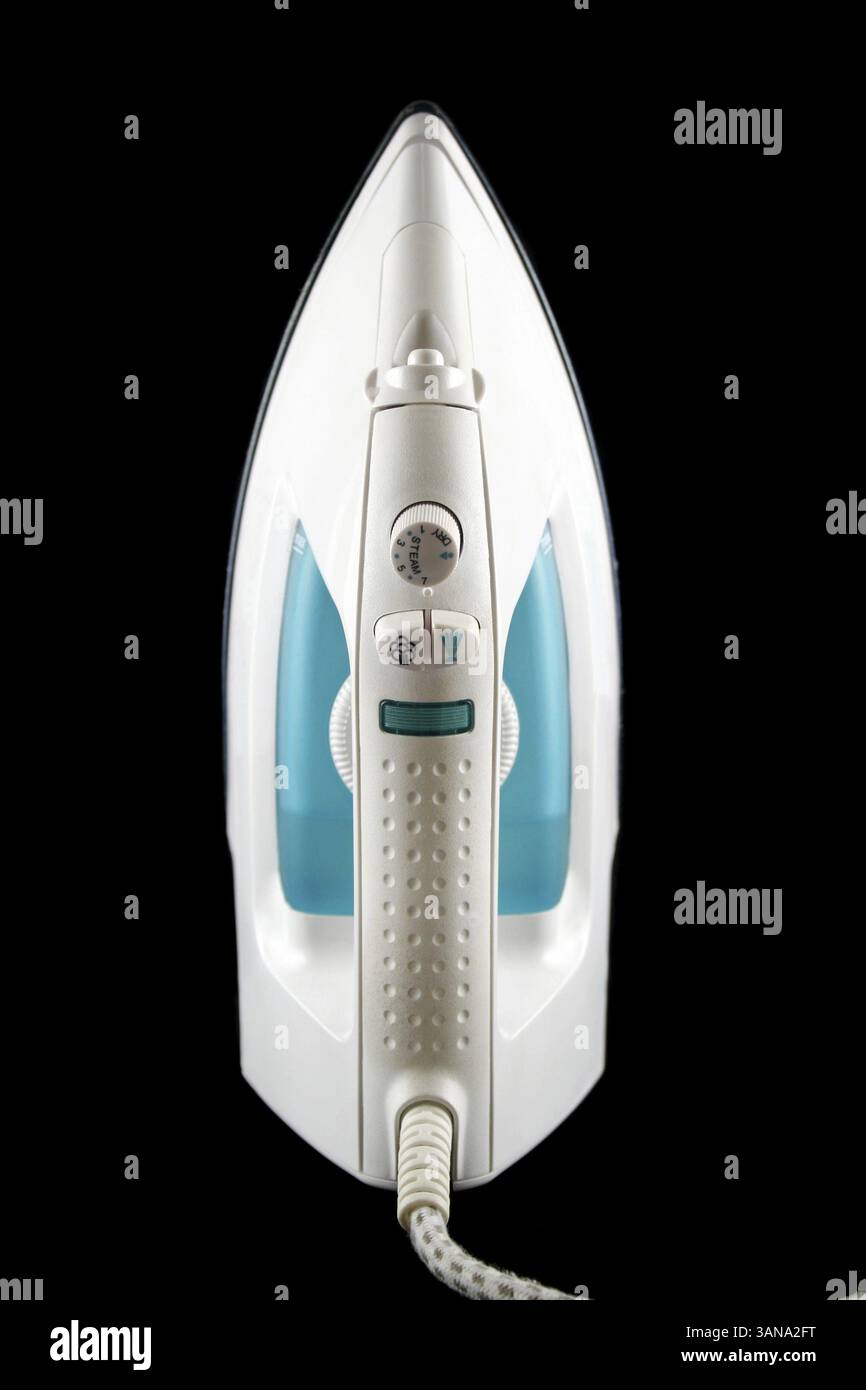 Steam iron sitting on its base with cord Stock Photo - Alamy