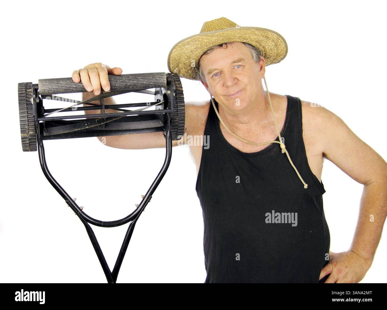 Middle aged gardner leaning on an old push mower Stock Photo - Alamy