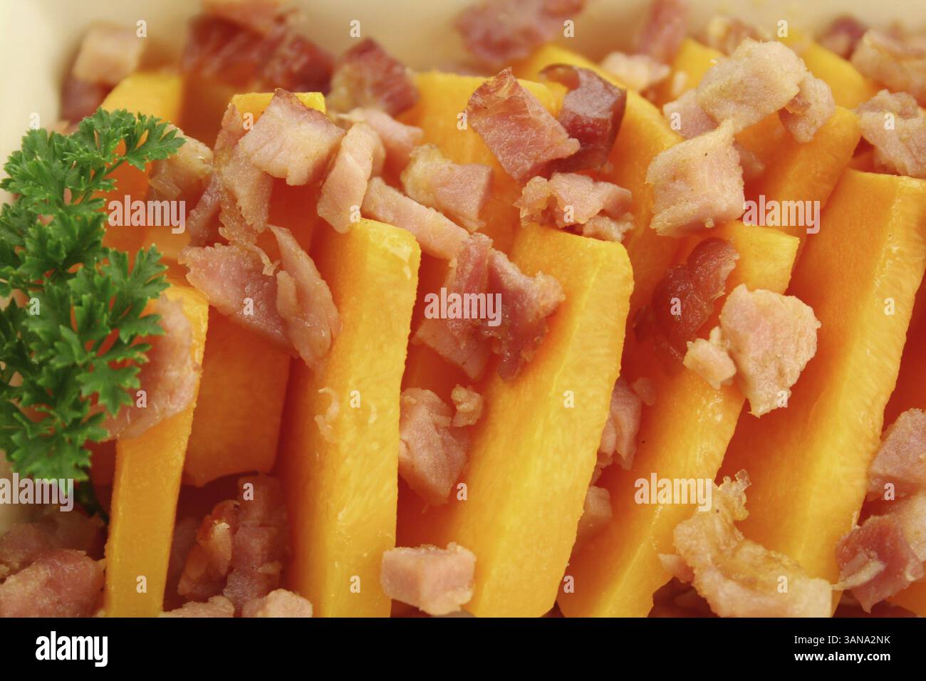 Baked sliced butternut pumpkin with bacon pieces ready to serve Stock ...