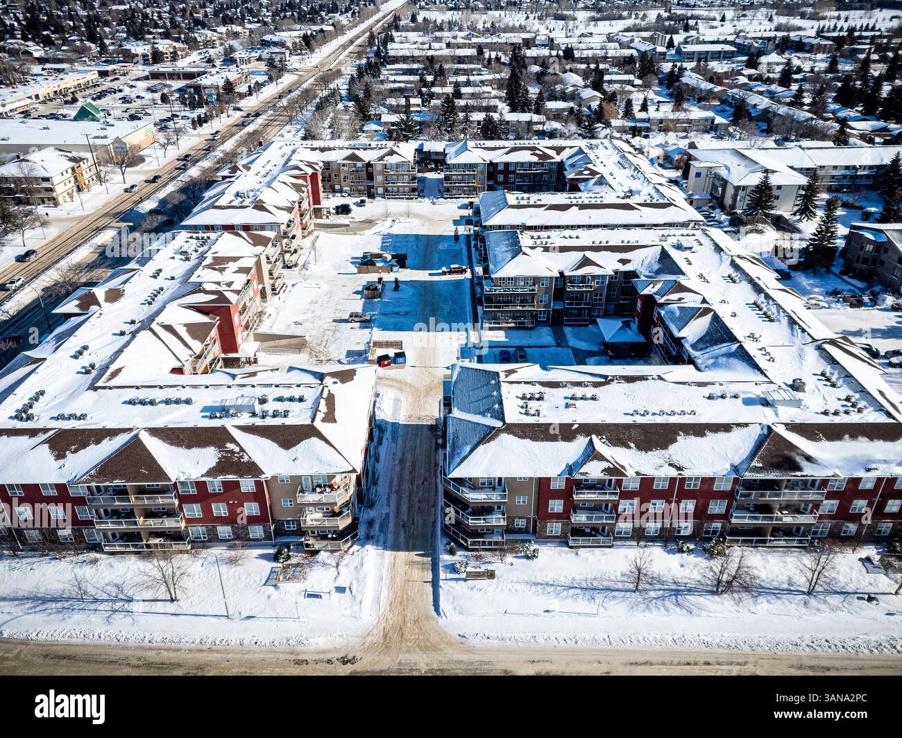 Snowy cityscape with a row of red buildings. The buildings are tall and ...