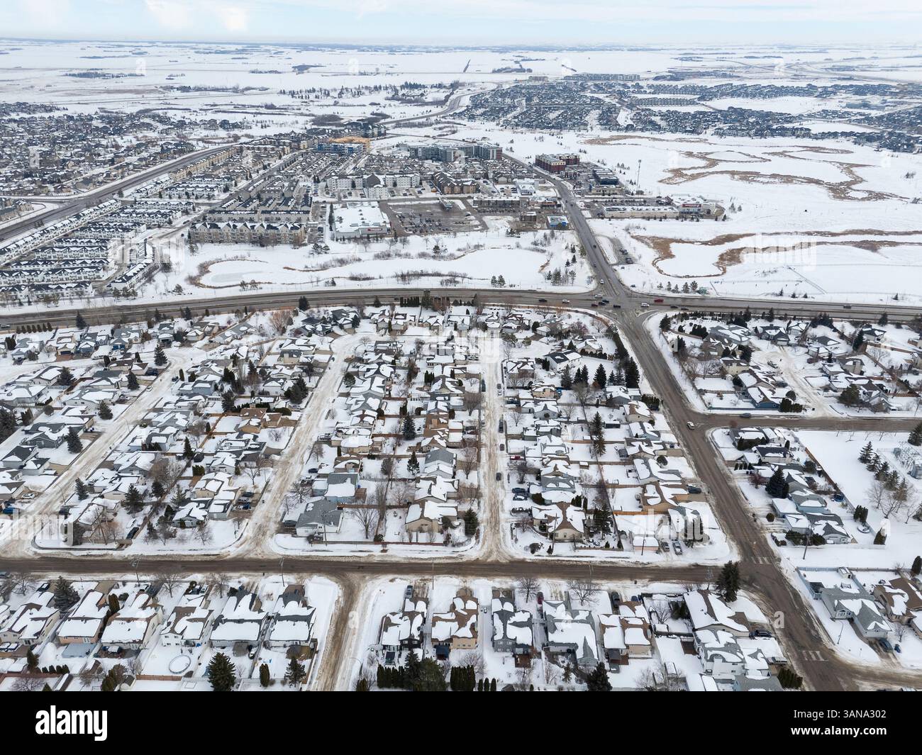 Snowy cityscape with houses and a street. The houses are all covered in ...