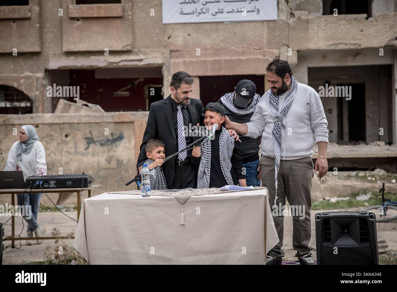 The son of singer Qassem Al-Jamous singing at an event in Yarmouk Camp ...