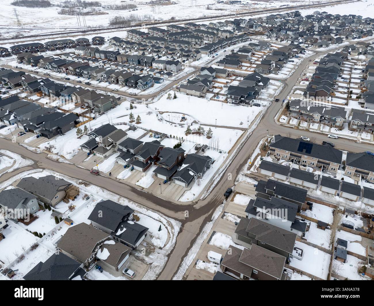 Snowy street with houses on both sides. The houses are all different ...