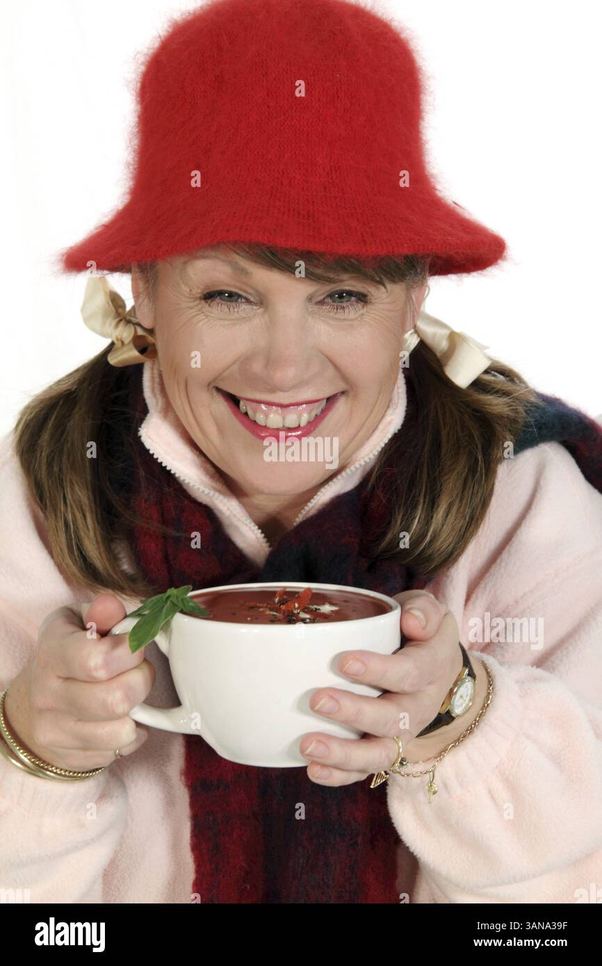 Middle aged woman rugged up for winter holding a hot cup of soup Stock ...
