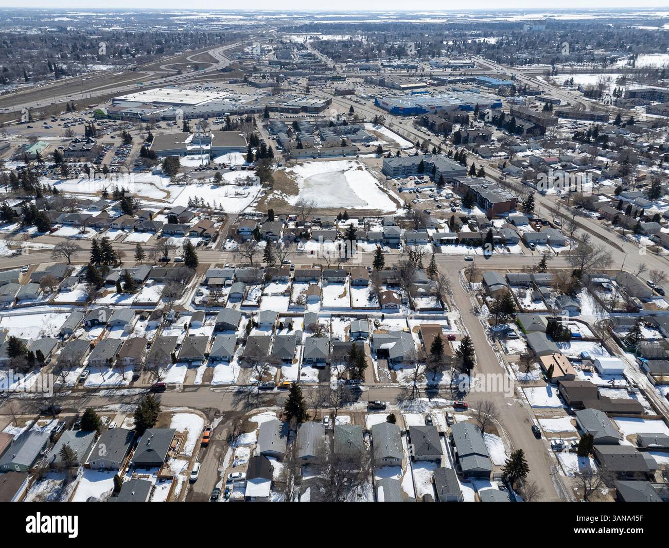 Snowy cityscape with houses and a street. The houses are small and the ...