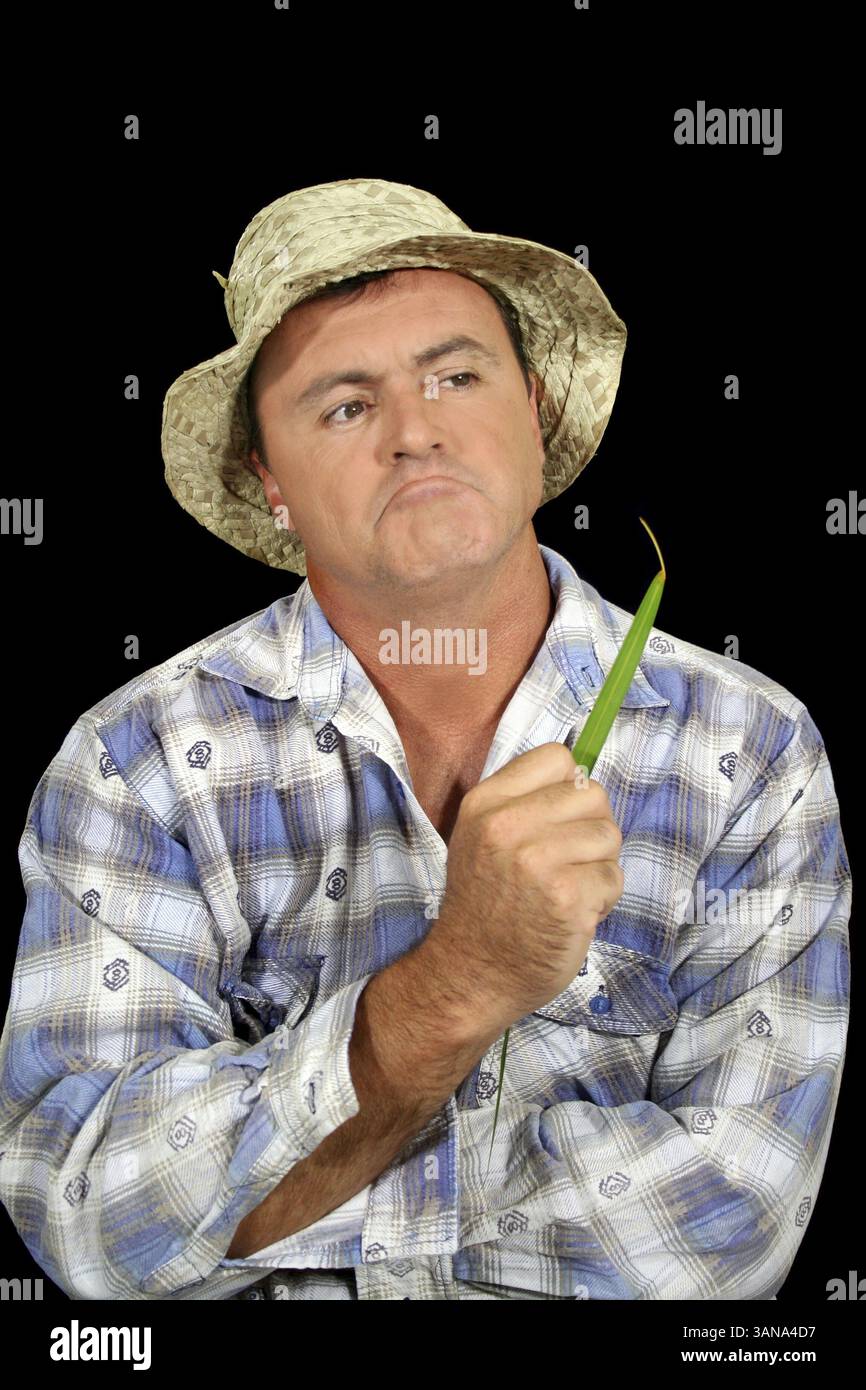 Farmer with an inquiring look and blade of grass Stock Photo - Alamy