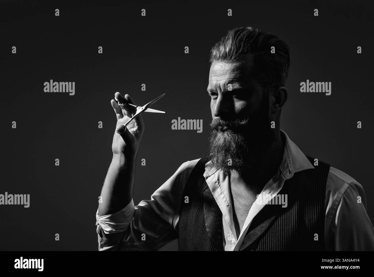 Handsome barber using scissors while cutting hair. Modern barbershop ...