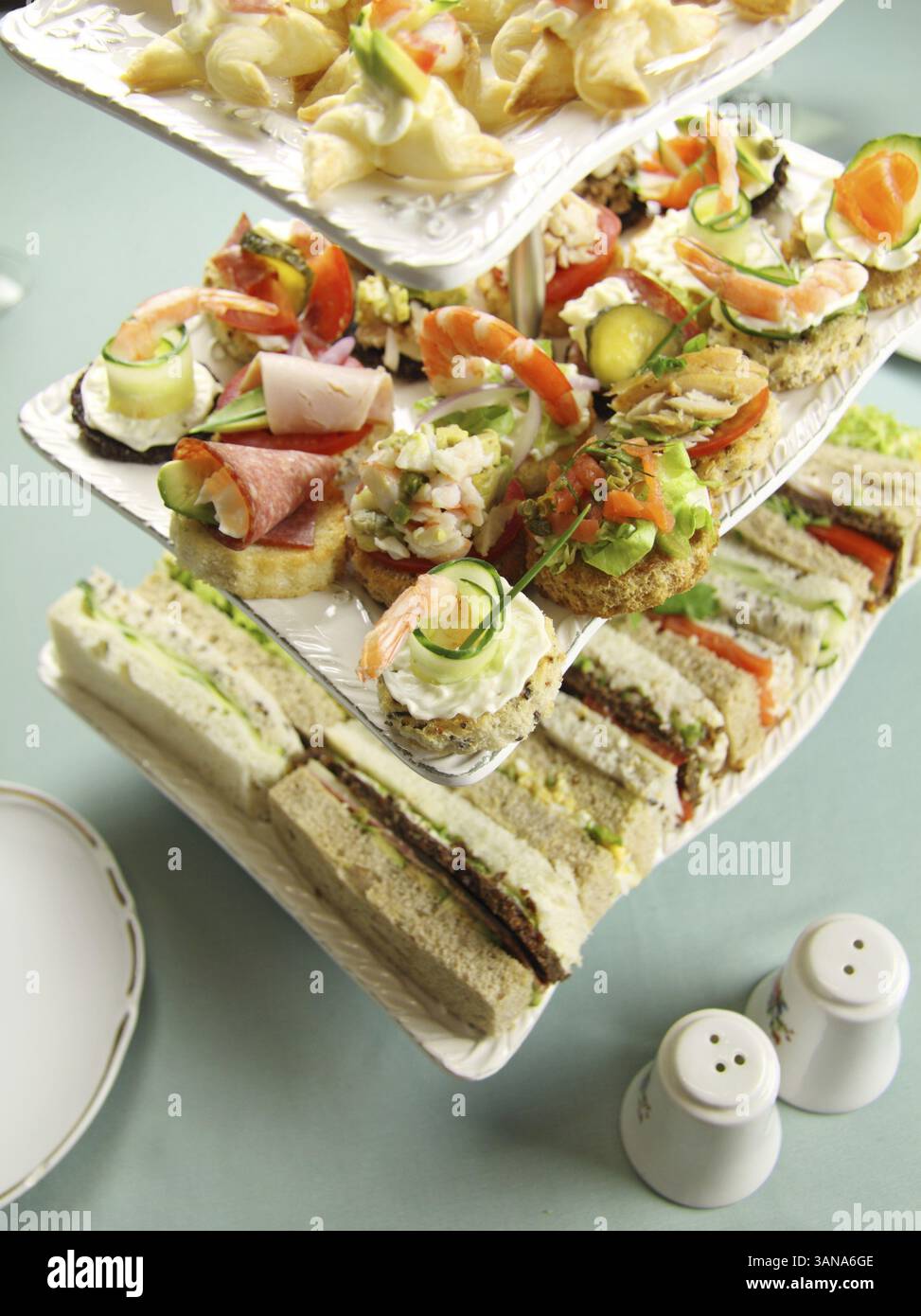 Delicious assorted finger food and sandwiches on a three tier stand ...
