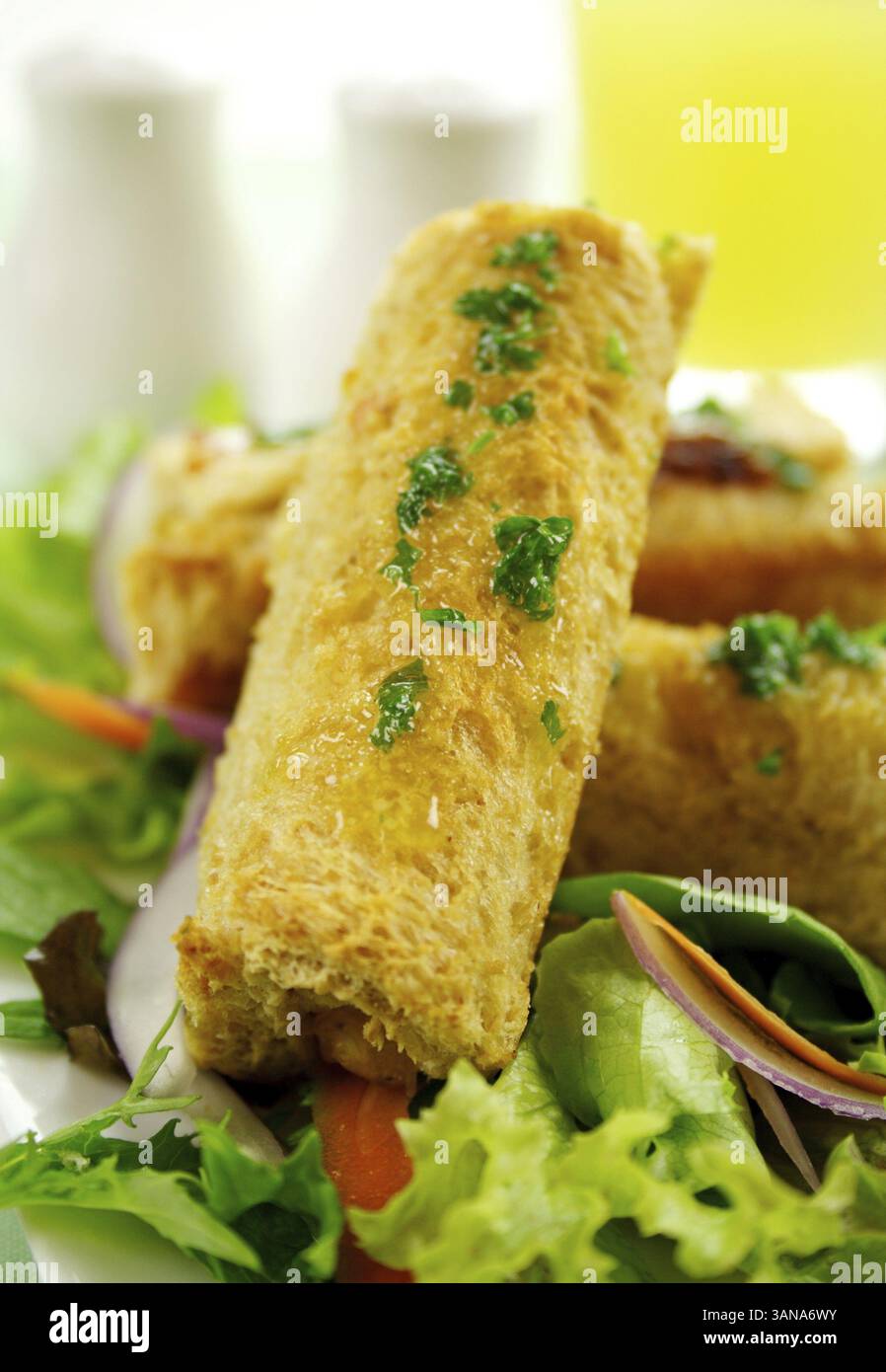 Vegetarian baked corn rolls dripping with parsley butter on a bed of ...