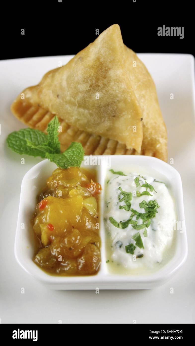 Indian samosa with mango chutney and herb yogurt Stock Photo - Alamy