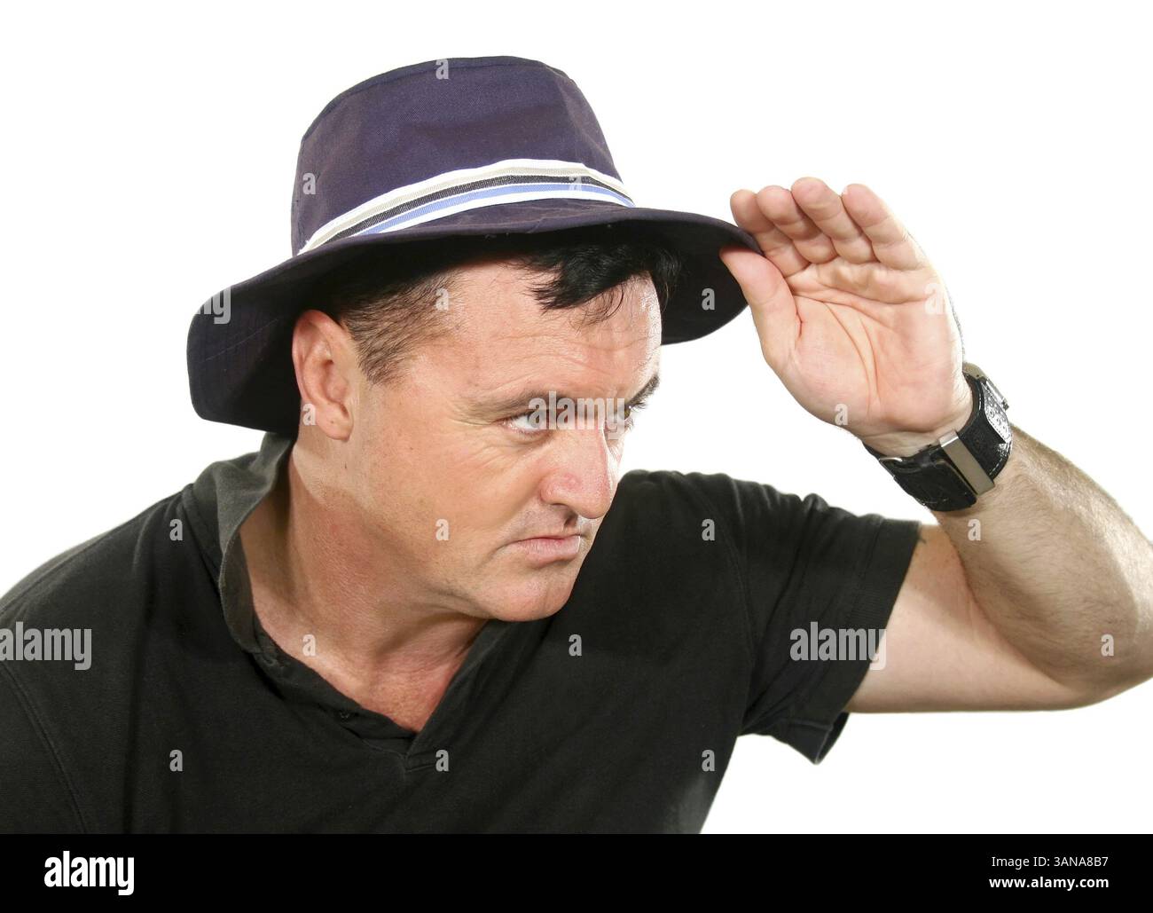 Man in hat looks away to camera right with hand on hat Stock Photo - Alamy