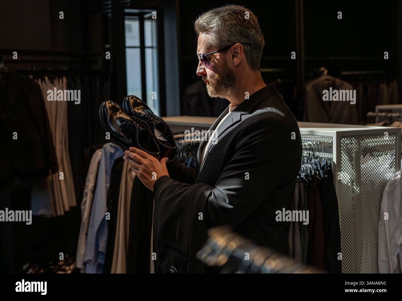 Shop assistant man in shoe store hold classic footwear. Shoe store ...