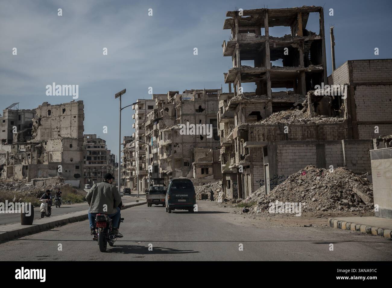 Traffic through central Homs, which is still badly damaged following ...