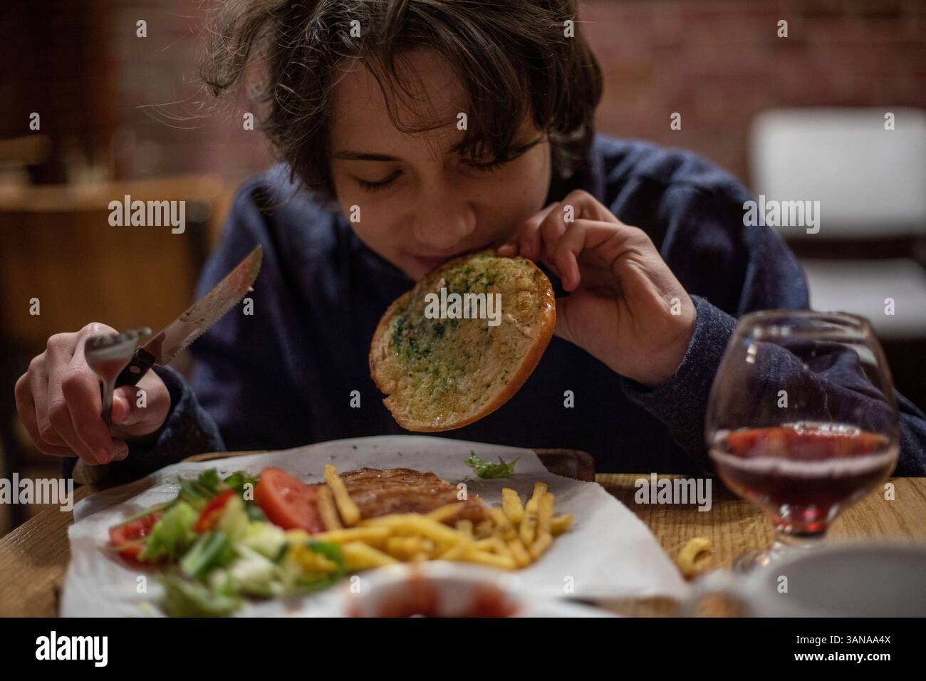boy eats pork chop with french fries and ketchup Stock Photo - Alamy