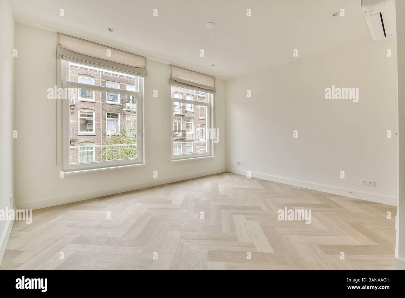Bright and airy minimalist living room featuring wooden herringbone ...