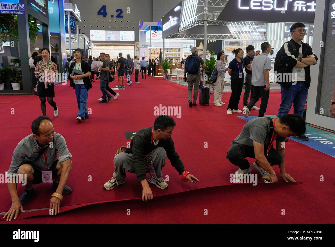 Workers adjust the red carpet at the 137th Canton Fair in Guangzhou ...