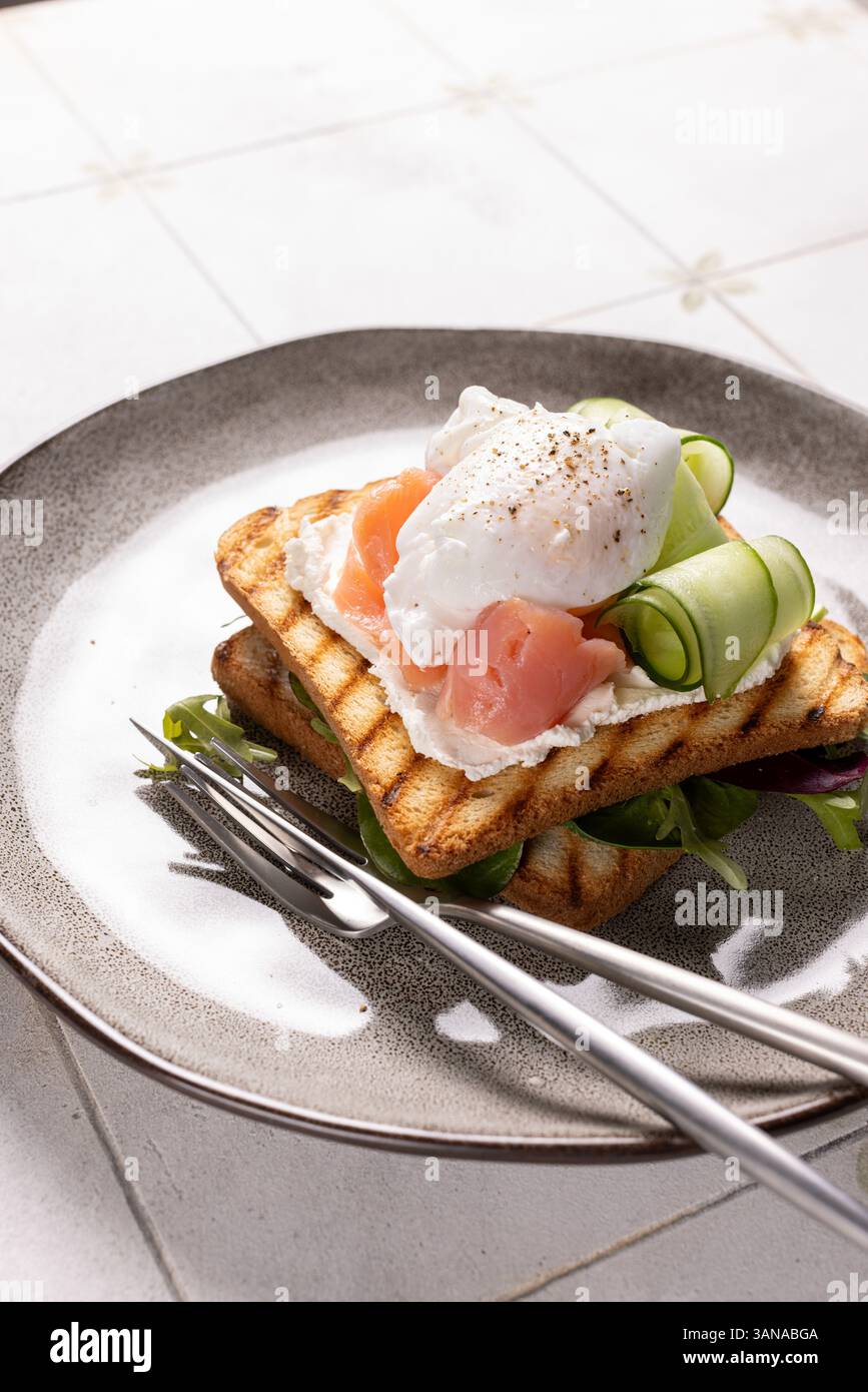 Toast with red fish, fresh cucumber and poached egg Stock Photo - Alamy