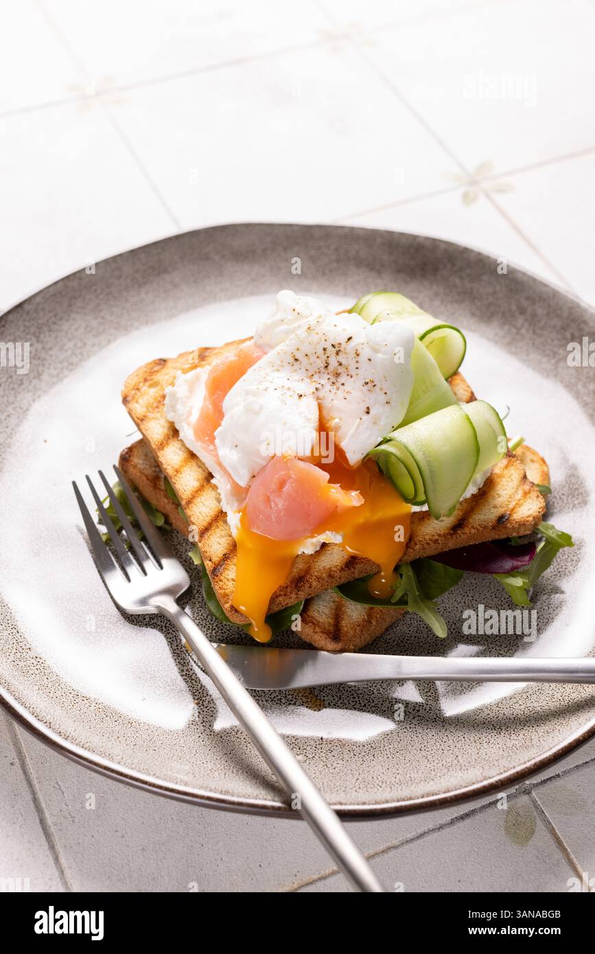 Toast with red fish, fresh cucumber and poached egg Stock Photo - Alamy