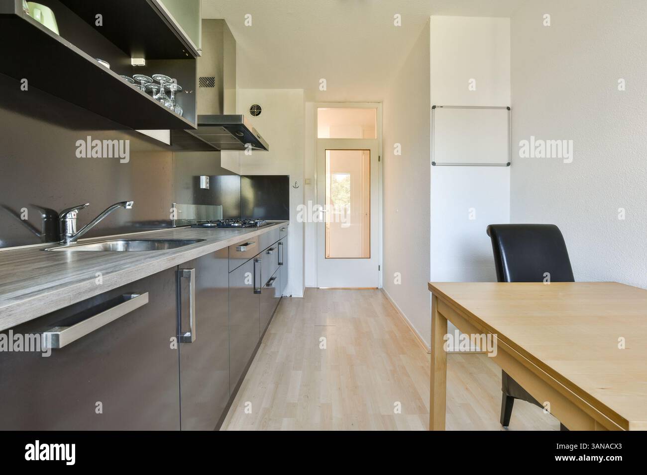 A sleek and contemporary kitchen featuring minimalist cabinetry, a well ...