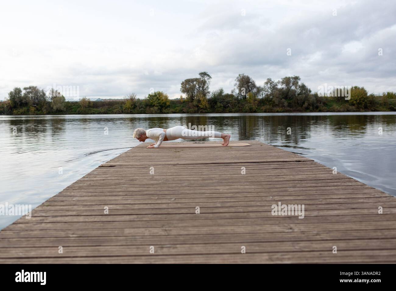 A mature woman practicing yoga, performing exercises on four limbs ...