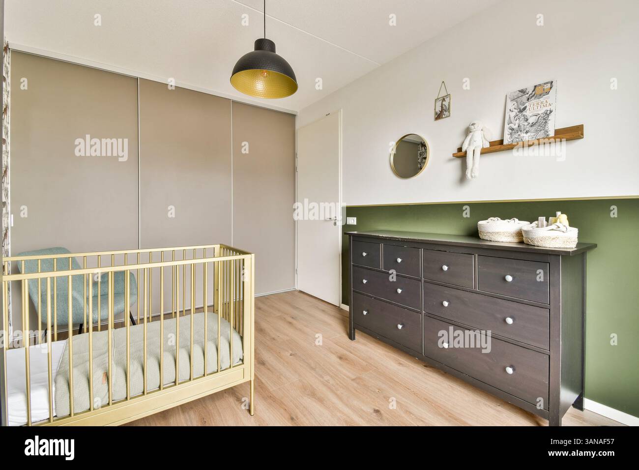 A stylishly designed nursery featuring a cradle, storage dresser, and ...